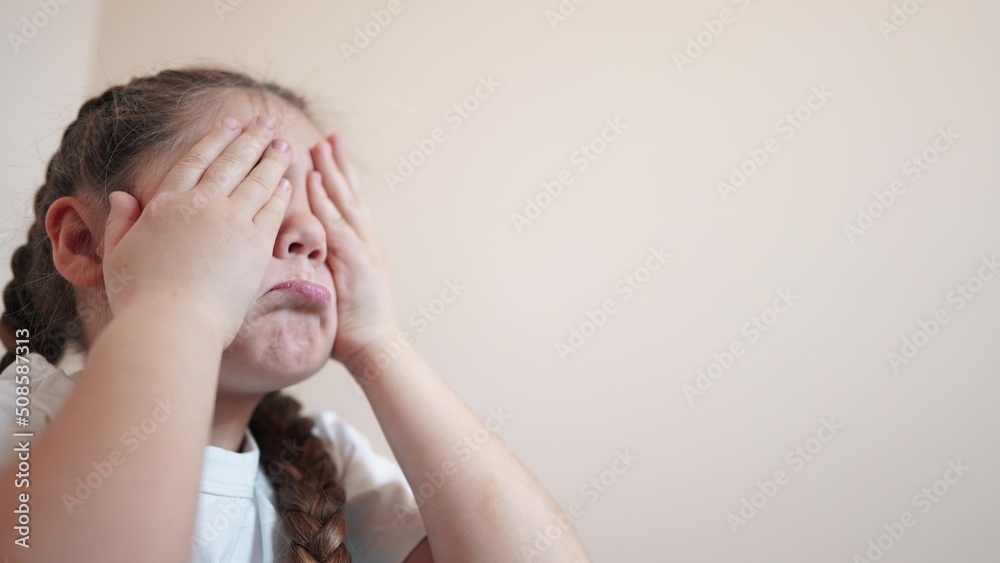sad girl sitting in the corner crying a covered her face with her hands ...