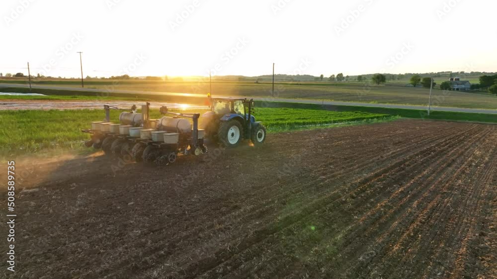 Drone view of tractor pulling seeder. Springtime planting in rural ...