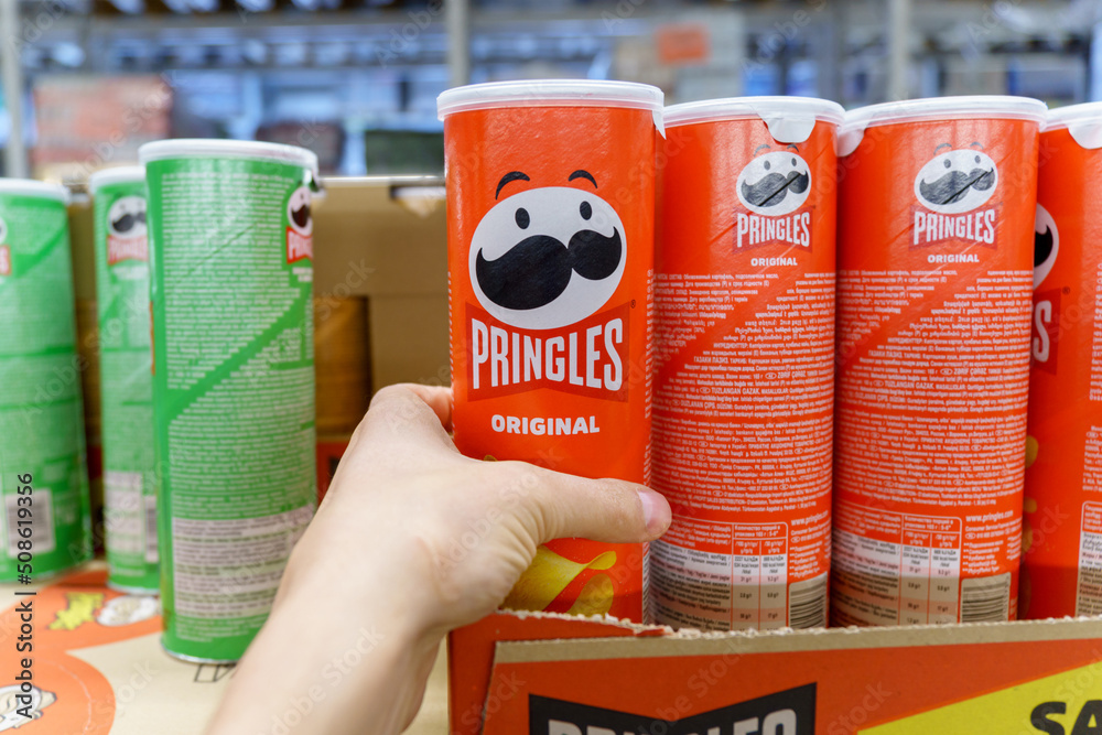 Tyumen, Russia-May 08, 2022: Hand hold a new tube of Pringles Potato ...