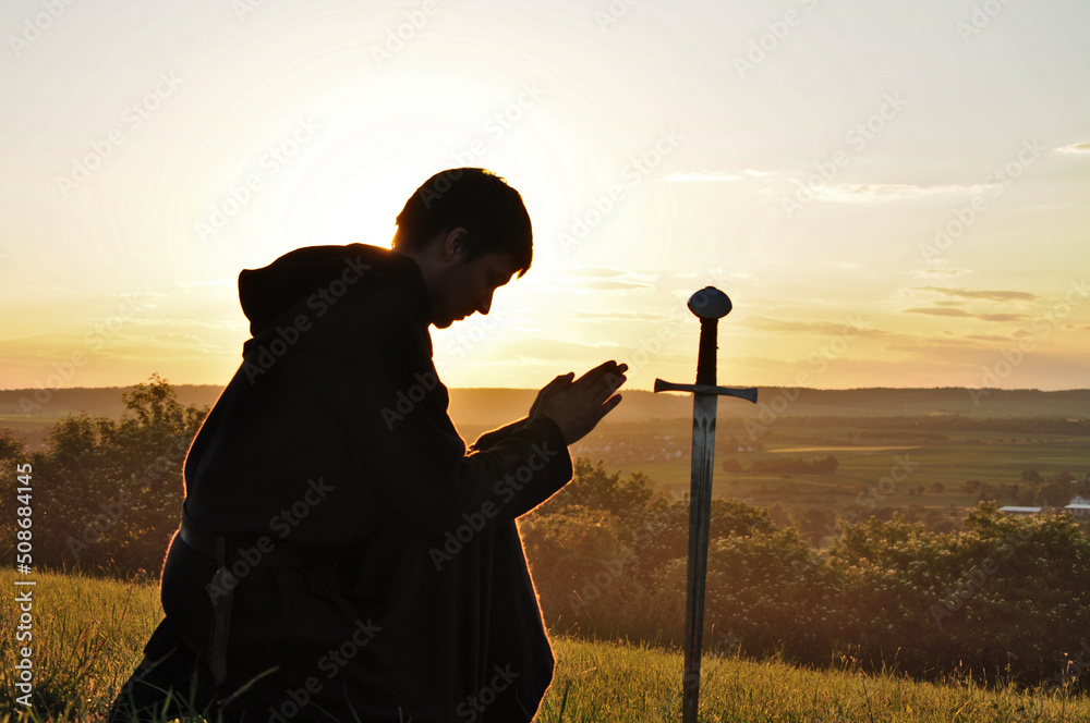 Monk praying in the sunset, Knight kneeling, praying to a sword in the ...