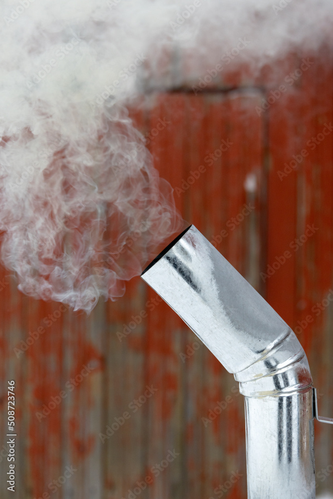 Puffs of smoke over the metal chimney of a classic Russian samovar ...