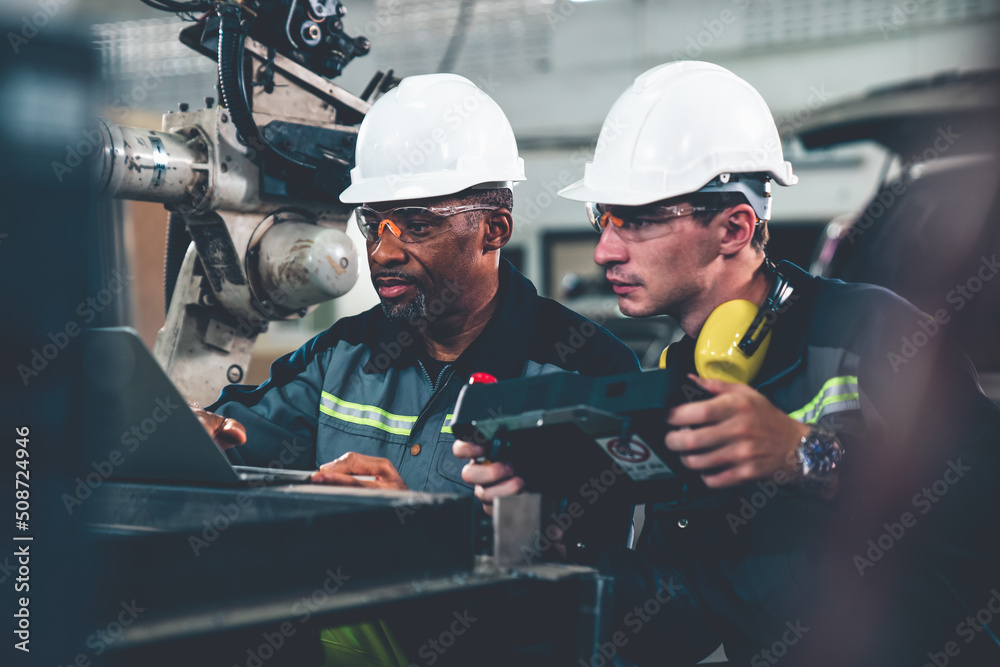Factory workers working with adept robotic arm in a workshop . Industry ...