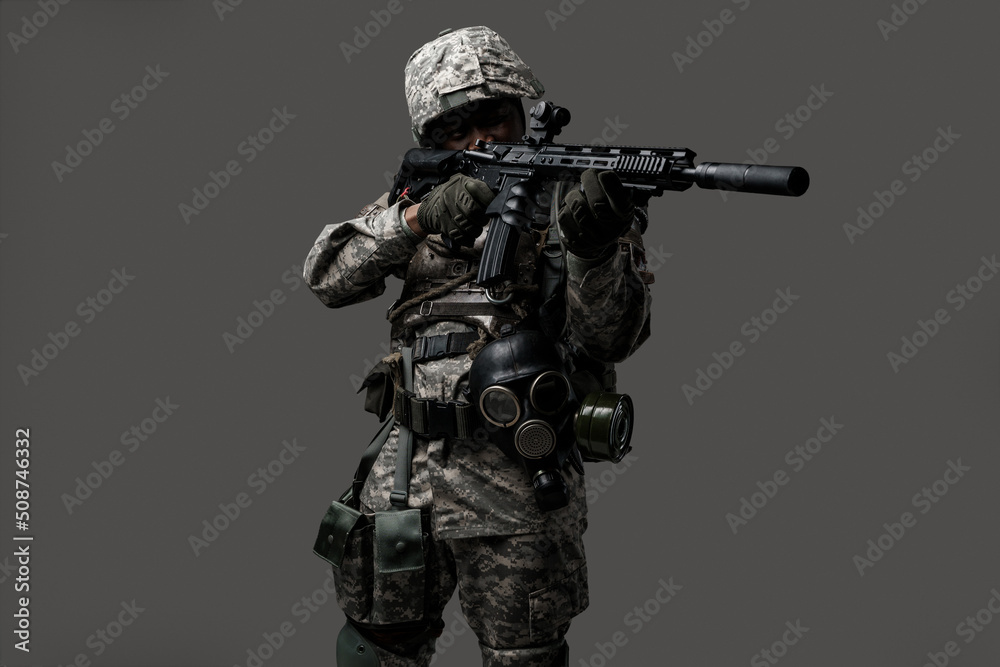 Portrait of brave army man dressed in modern camouflage uniform aiming ...