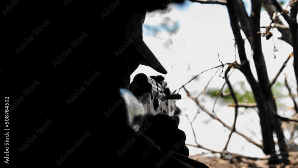 Video Stock Backlit soldier aiming at an AK-47 scope during combat duty ...