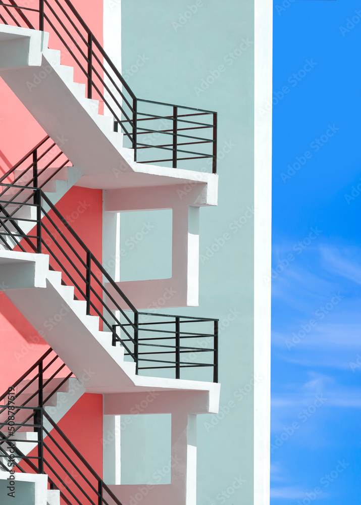 Side view of white fire escape outside of colorful pastel apartment ...