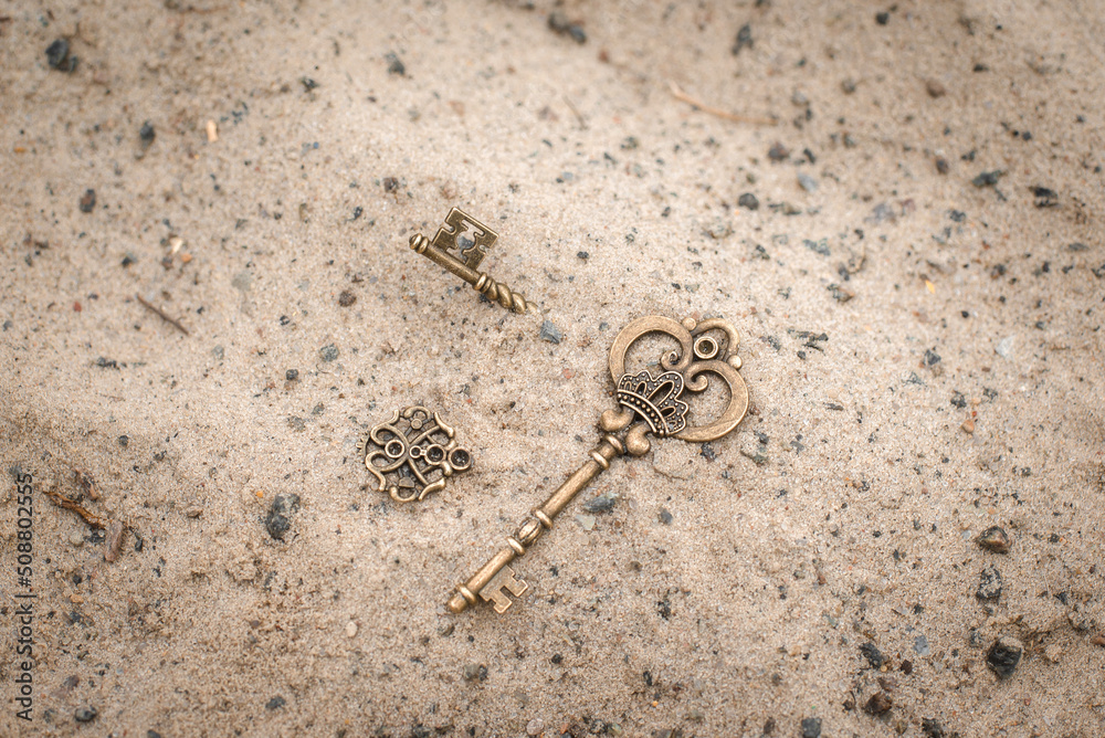 Ancient key in the sand. Lost vintage key. Golden treasure in the ...