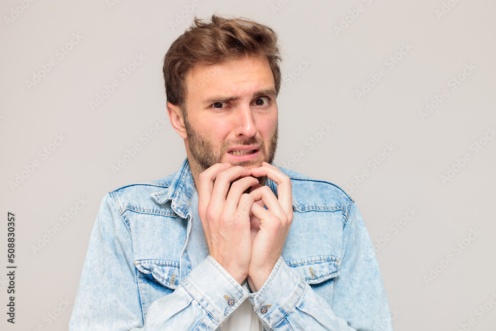 Annoyed young Caucasian male clenches teeth and looks with displeased ...