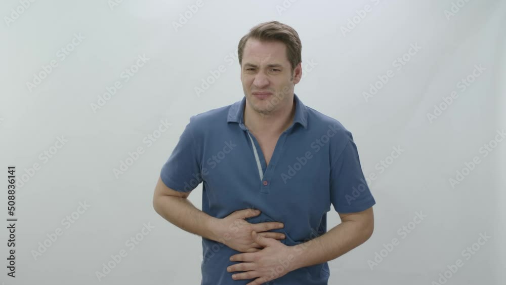 Man squeezing his stomach with his hands due to abdominal pain.A man ...