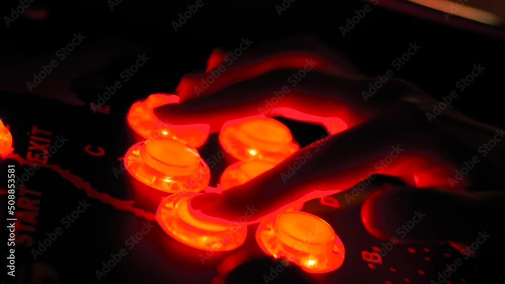 Woman hands playing retro arcade machine game and pushing bright red ...