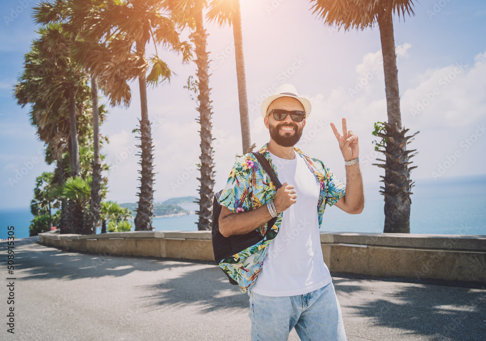 Young traveler man at summer holiday vacation with beautiful palms and ...
