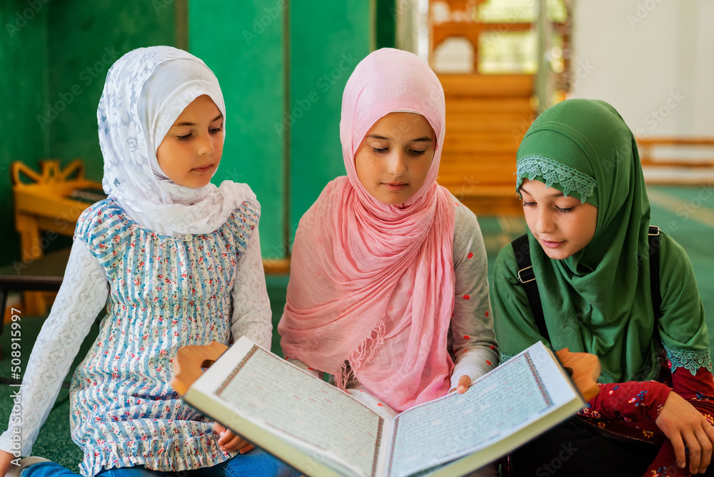 A group of children reads the holy book Quran in the mosque. Happy ...