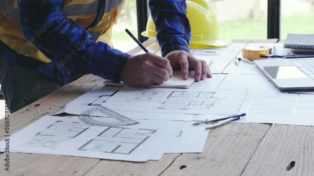 architect reviewing blueprints and holding pencil drawing on desk at ...