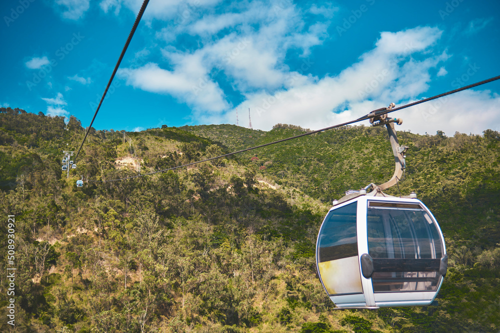 Modular cabins cable car against the bright sky, clouds ans mountains ...