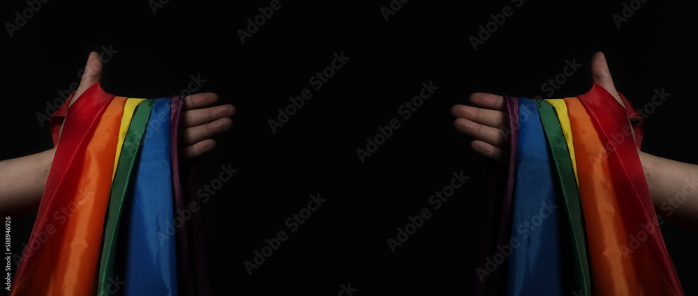 LGBTQ pride flag on black background. Lgbt rainbow flag in gay hand ...