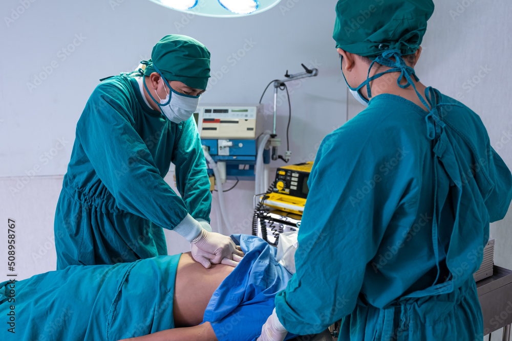 Doctor and nurse using defibrillator to pump at chest of unconscious ...