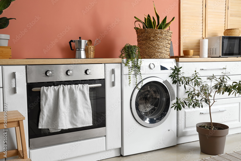 Stylish interior of kitchen with modern washing machine Stock Photo ...