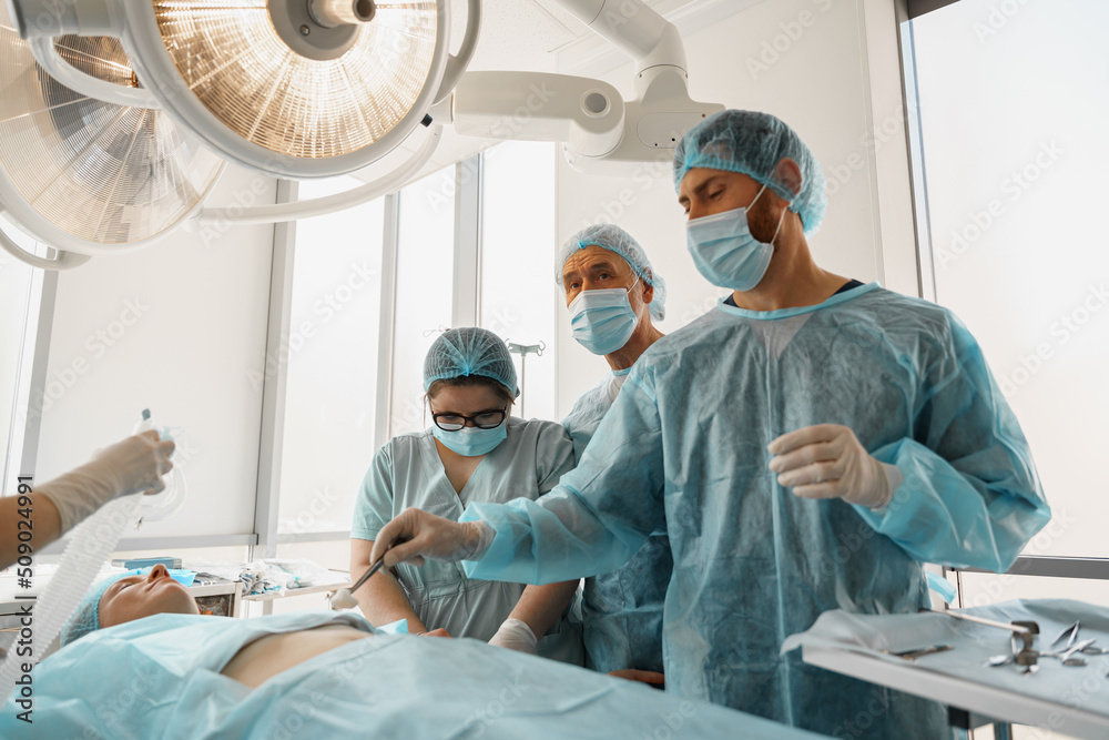 Nurse and doctor prepare patient skin for surgery using antiseptic ...