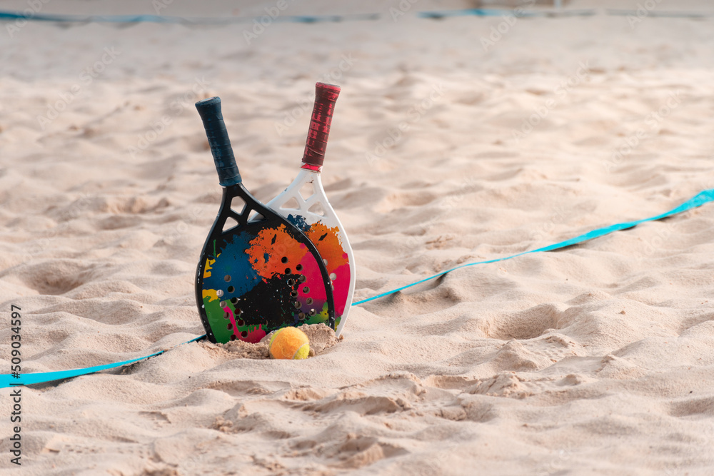 Foto de Beach tennis rackets and balls on the beach sand do Stock ...
