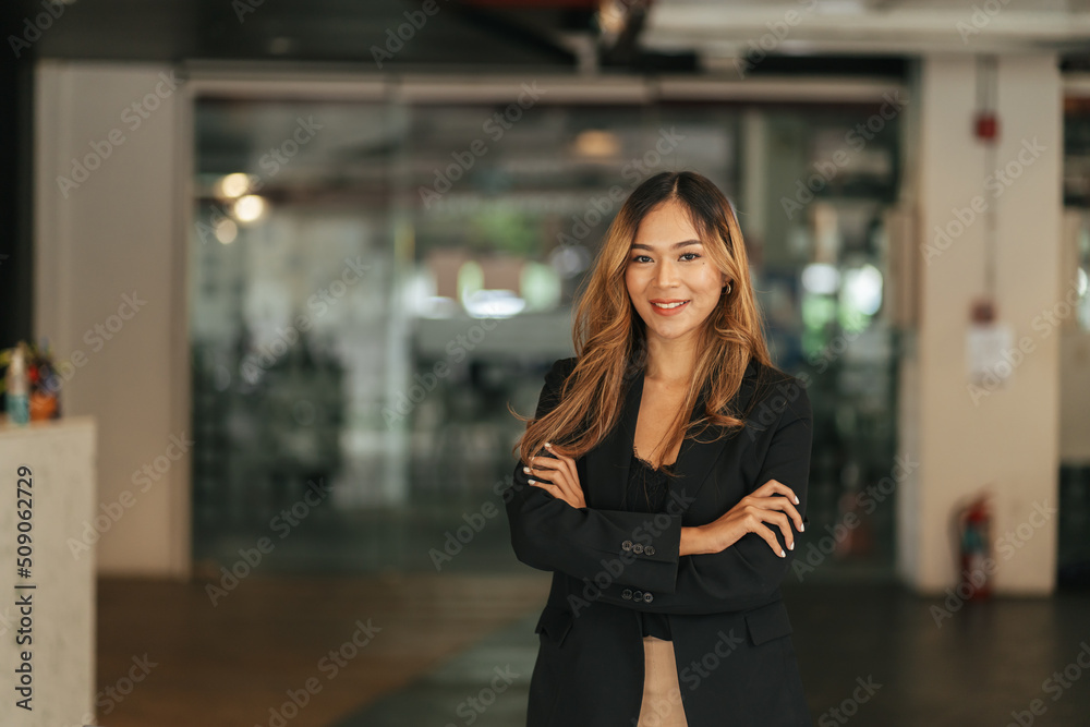 Smiling beautiful female professional manager standing with arms ...