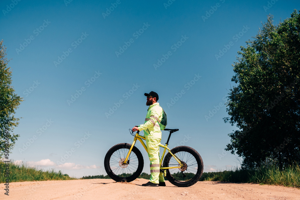 Fat-tire bike in summer driving through the hills. Man is posing with a ...