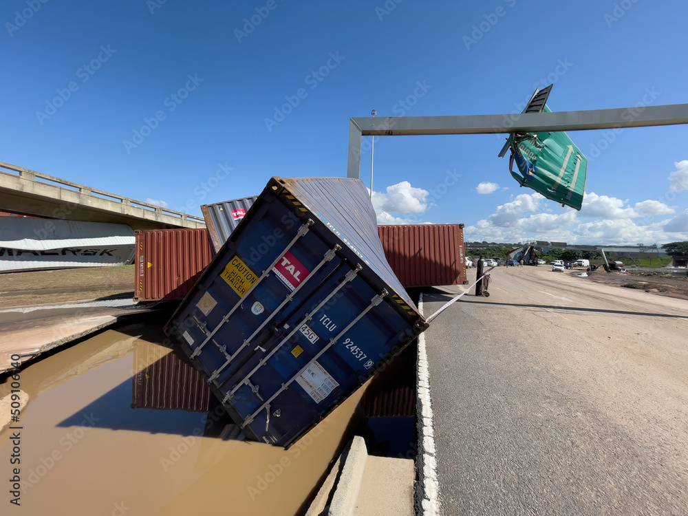 A shipping container has twisted around a road sign frame on the main ...
