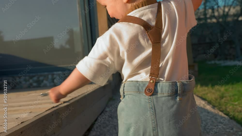 Mother leads little son with key in hand to big house on sunny day ...