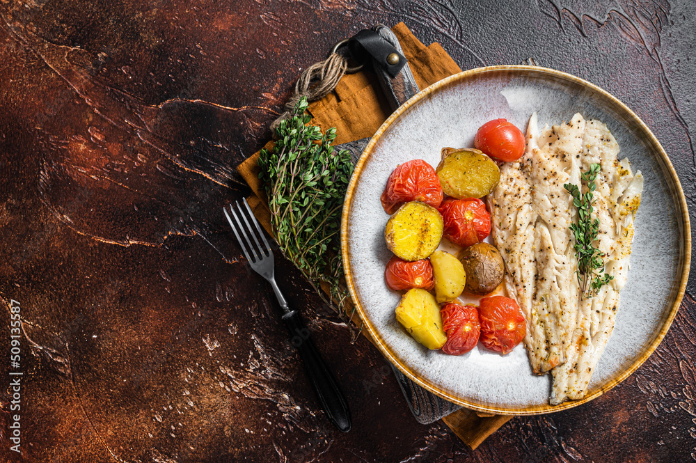 Roasted Pollock fish fillet in plate with garnish tomato and potato ...