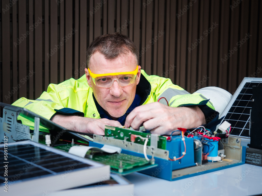 Professional solar cell engineers wearing safety vest and hardhat are ...