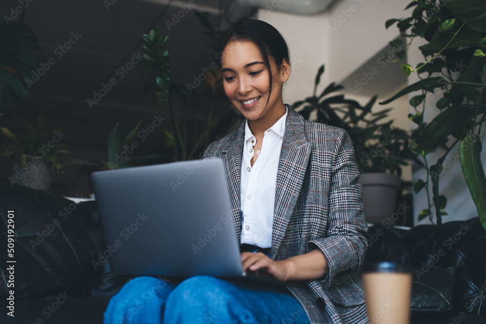 Happy Asian female freelancer enjoying remote working on laptop computer using 4g wireless for ...