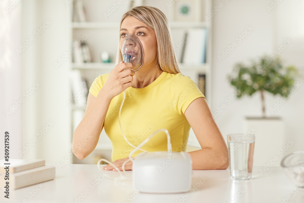 Young woman sitting on a table and using an inhaler Stock Photo | Adobe ...