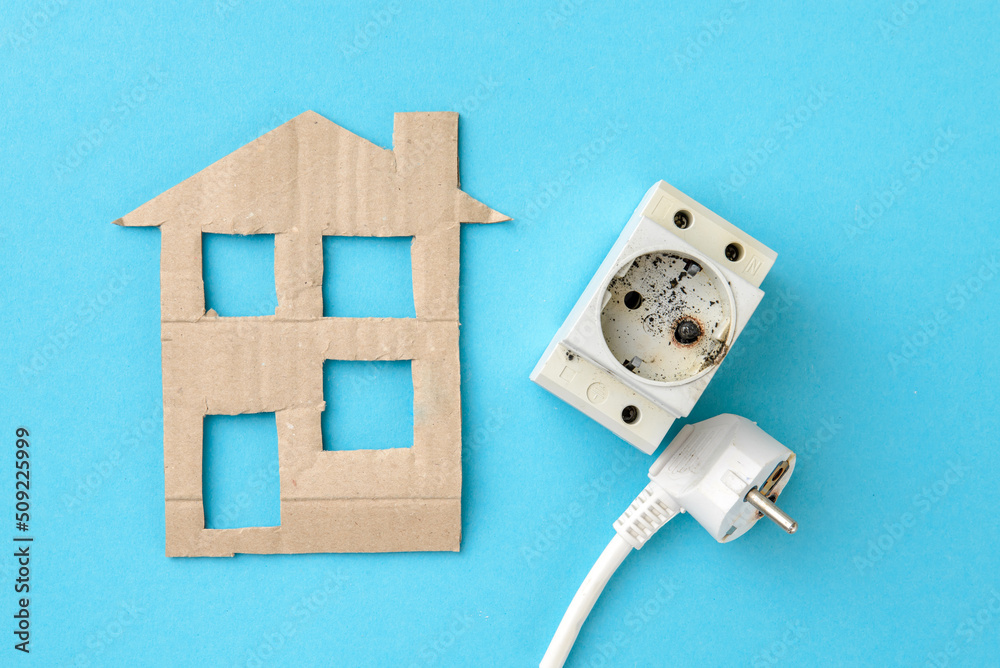 Flat lay of cardboard house and burnt electrical appliances of home ...