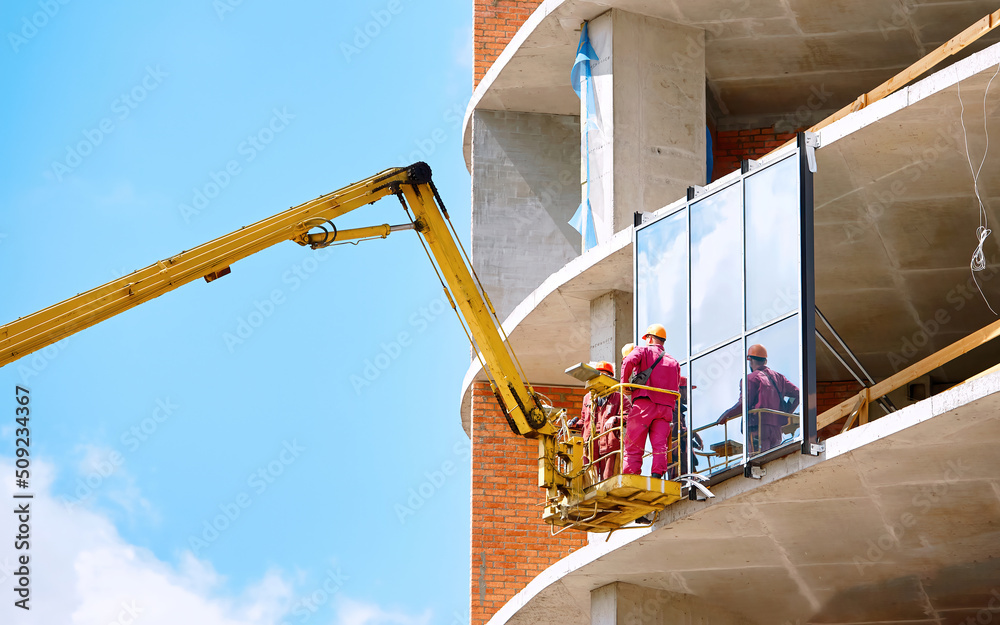 Builders team installing double glazed windows on high-rise building ...