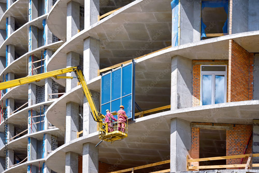 Fototapeta Workers installing double glazed window on high-rise ...