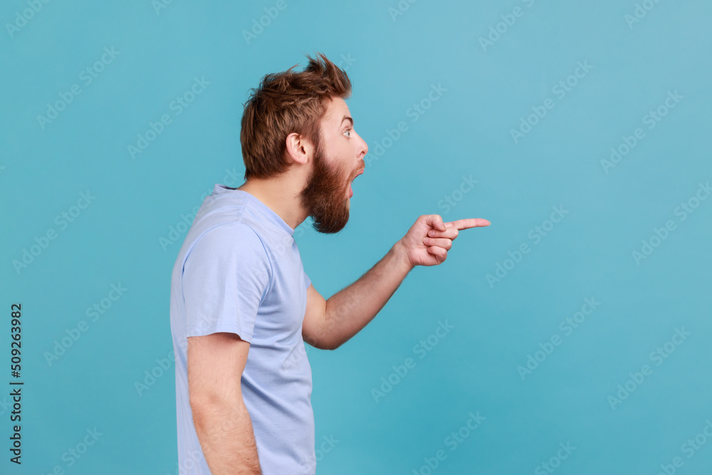 Poster Side view of surprised shocked bearded man pointing aside ...