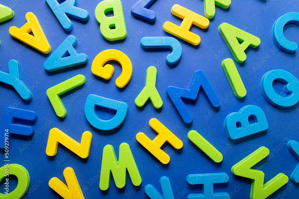 Scattered letters on blue background. Several capital letters in ...