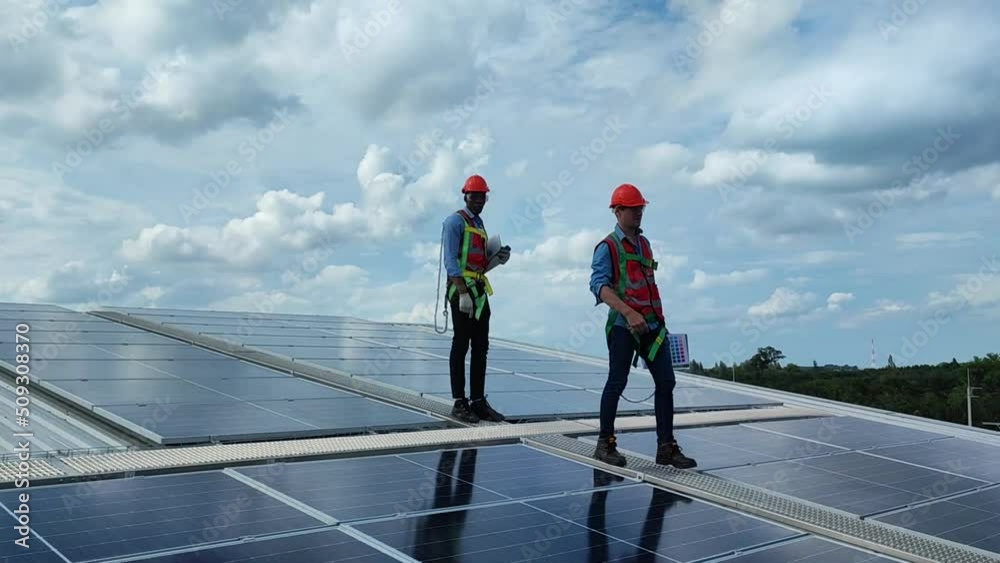 New solar farm under the blue sky. Workers in special outfit walk and ...