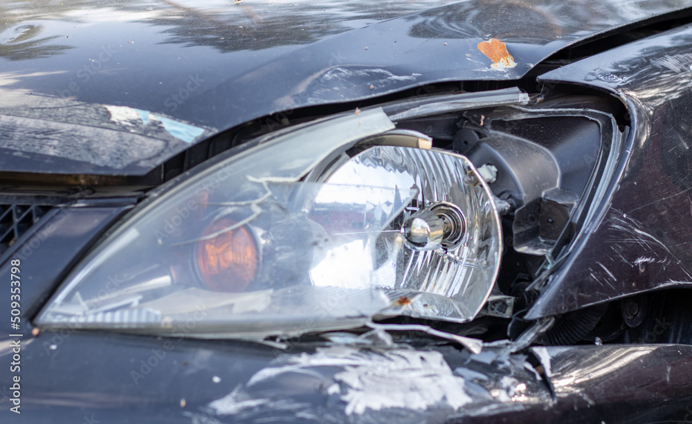 Broken headlights as a result of a collision. Broken black car after an ...