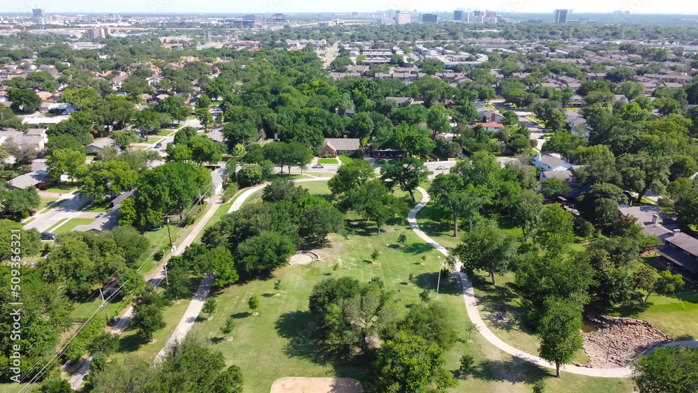 Lush green grassy park with trail system and matured trees near ...