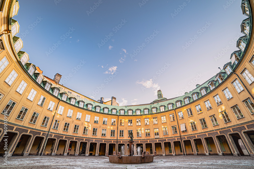 Neat crescent, round shaped building wrapping a small cobbled square ...
