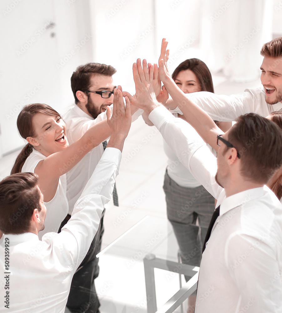 successful business teams make a high five over their Desk Stock Photo ...