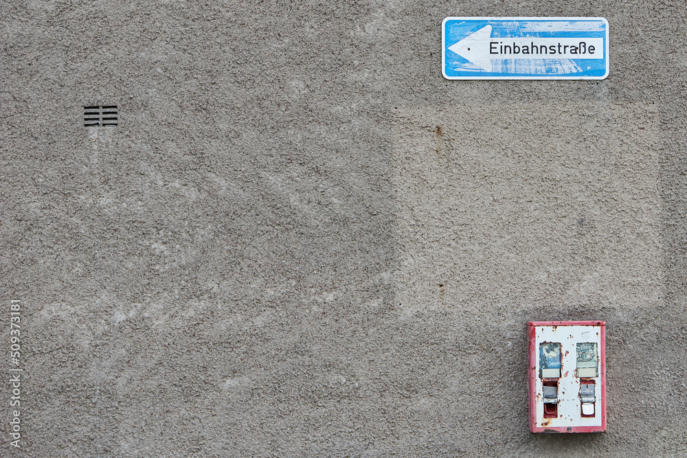 vintage gumball machine fixed on a wall and a German one way sign Stock ...