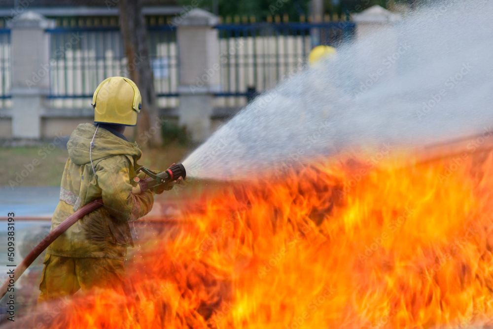 fire fighter Using water mist fire extinguishers to combat oil flames ...