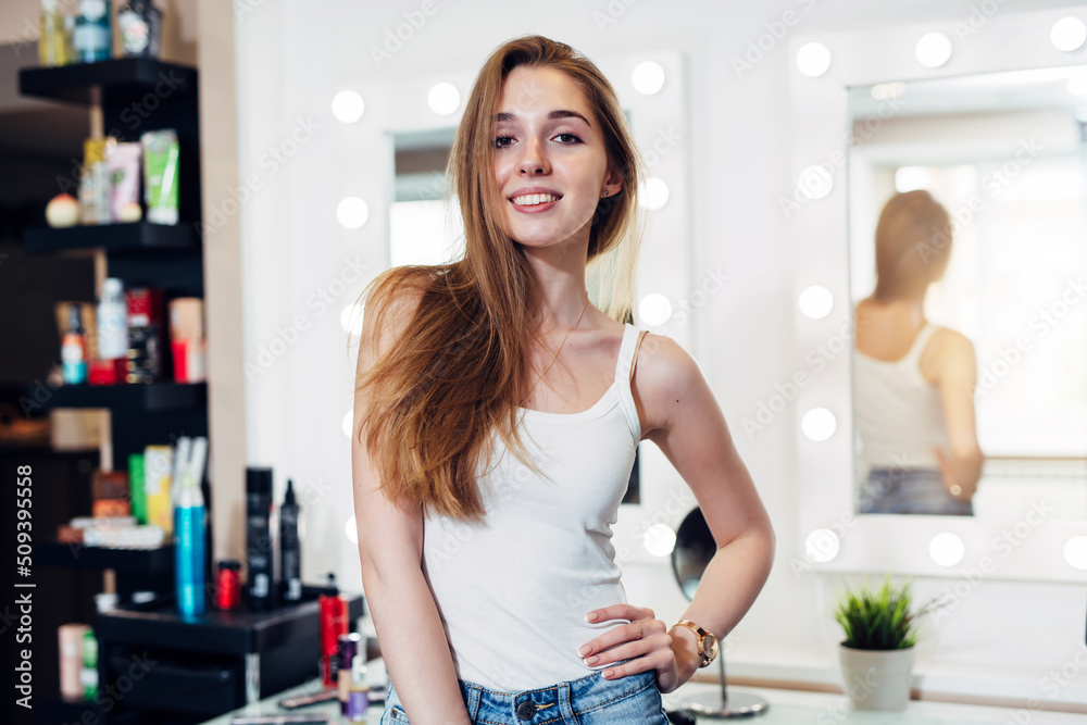 Portrait of pretty female beautician standing posing at workplace in ...