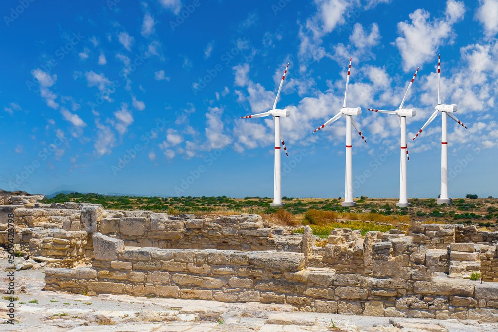 Windmills in summer. Environmentally friendly power plant next to ruins ...