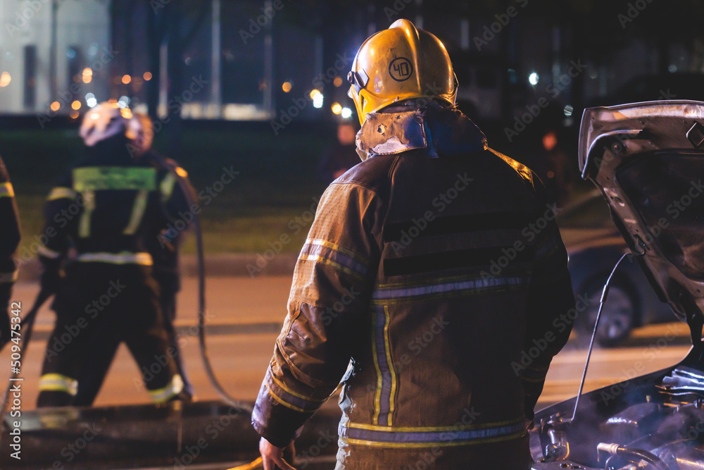 Group of fire men in uniform during fire fighting operation in the ...