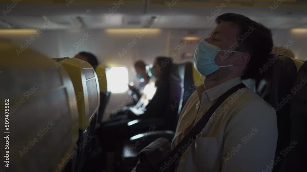 Tourism and flying in times of covid. A tired man trying to sleep on an ...