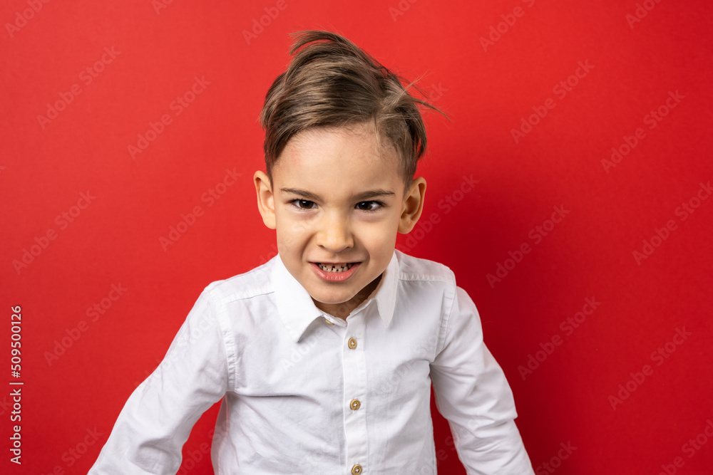 One boy male child five years old in front of red background wall ...