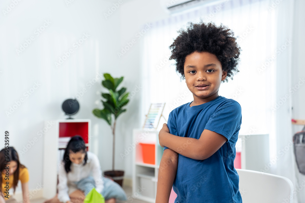 Portrait of African black child boy standing crossed arm in classroom ...