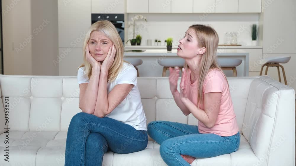 Adult daughter scolds her older stubborn mother. Daughter-mother conflict. Two different age ...