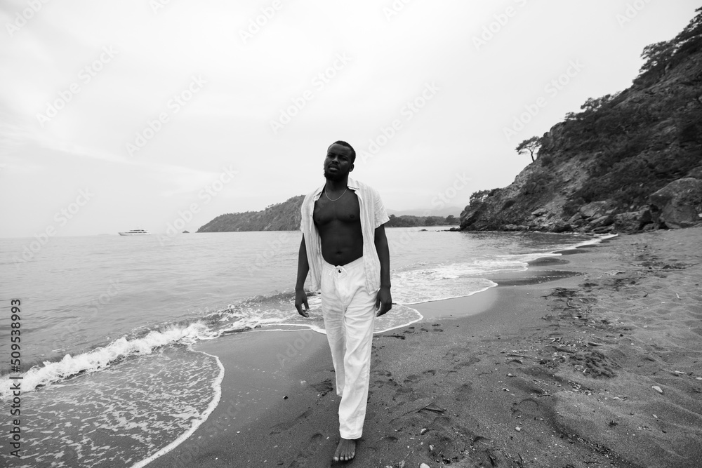 black male model sunbathing on the beach and reading a magazine Stock ...